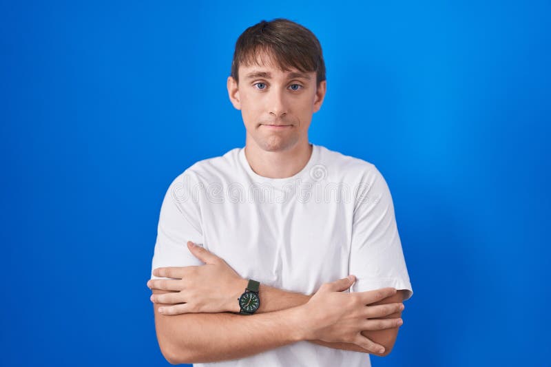 Caucasian Blond Man Standing Over Blue Background Shaking and Freezing ...