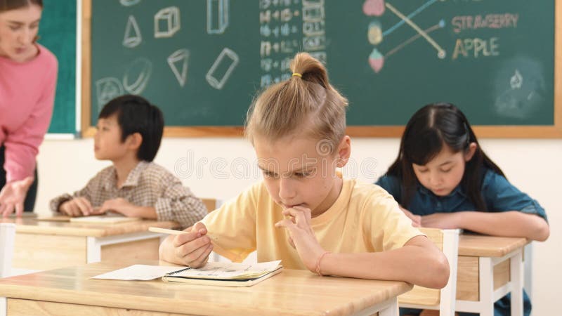Caucasian Child Smiling at Camera while Doing Classwork at Classroom ...