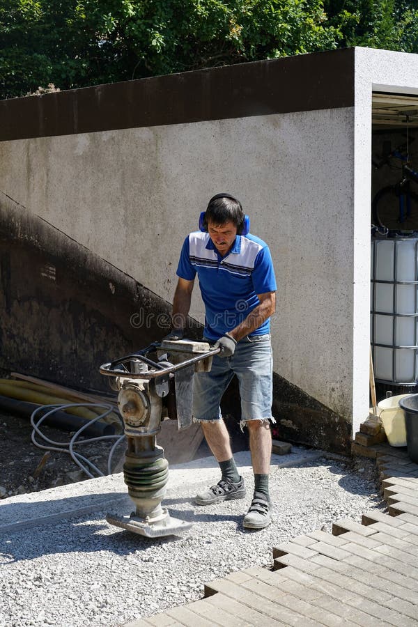 Caucasian Construction Worker Compacting Soil Using a Tamping Rammer ...