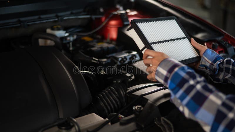 Caucasian Female Auto Mechanic Changes the Engine Air Filter in the Car ...