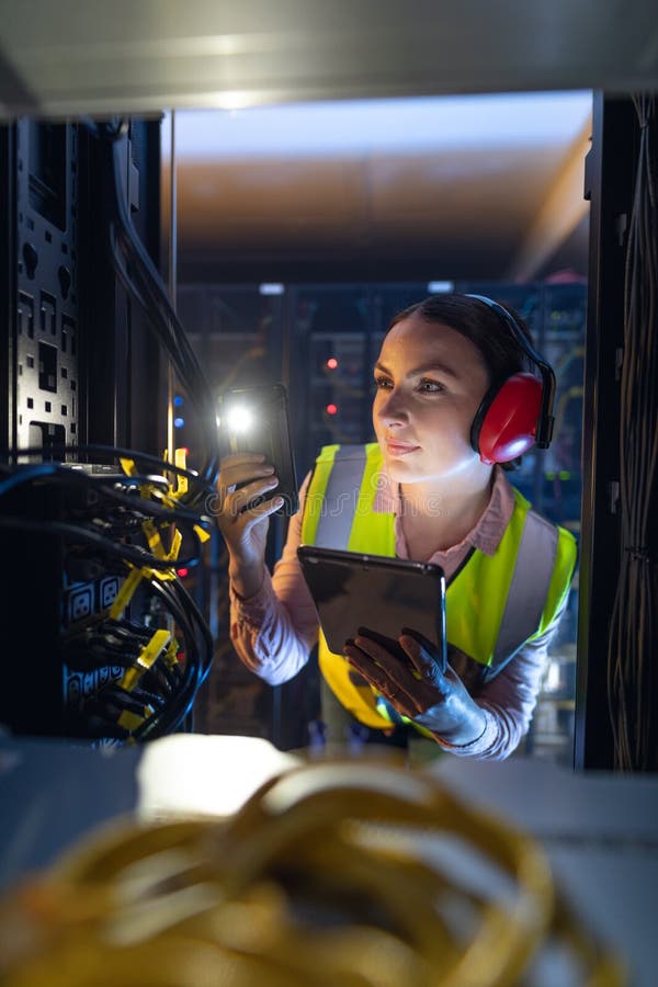 Caucasian Female Engineer Using Smartphone Flash while Inspecting the ...