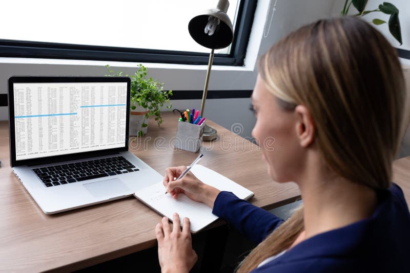 Caucasian Female Programmer Sitting At Desk Using Laptop With Coding