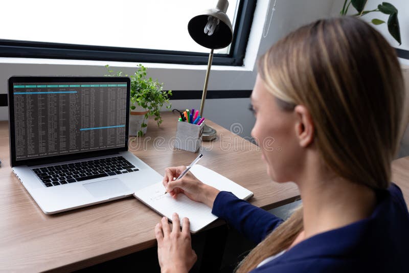 Caucasian Female Programmer Sitting At Desk Using Laptop With Coding