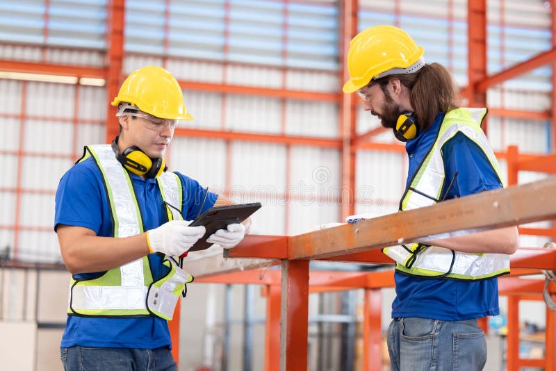 Caucasian Iron Welding Workers with Tablet in Front of the Red Steel ...