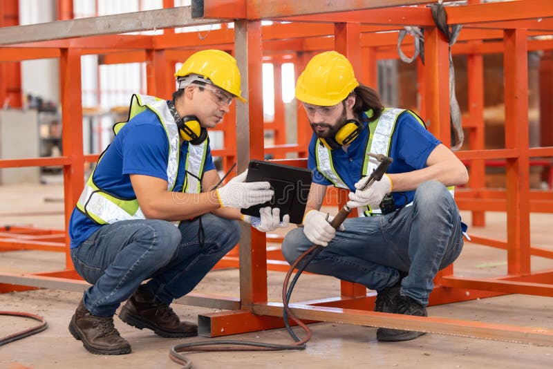 Caucasian Iron Welding Workers with Tablet in Front of the Red Steel ...