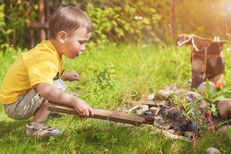 Caucasian Little Boy Dealing with Fire Near Firepace Outdoors. Stock ...