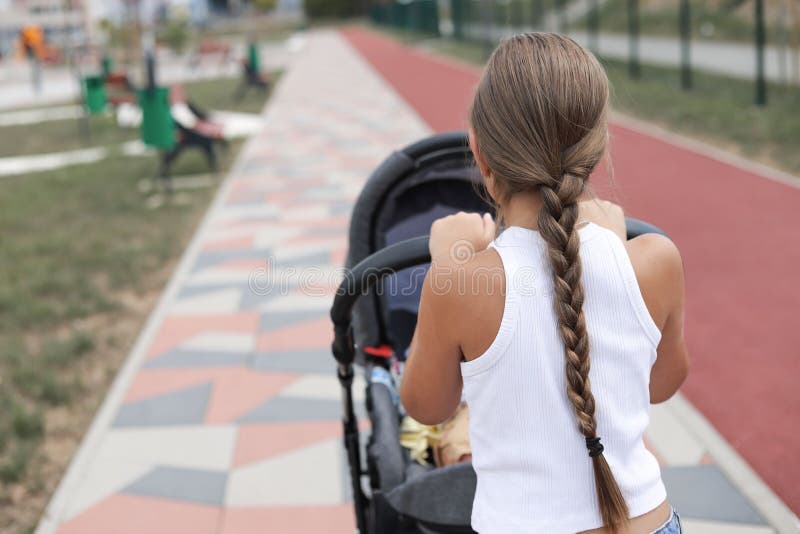 Caucasian Little Girl Pushing a Stroller in a Park Stock Photo - Image ...