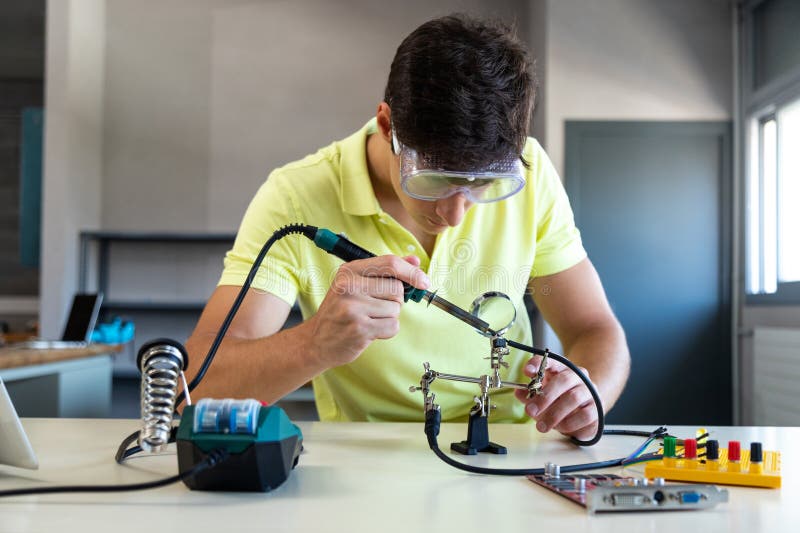 Caucasian Male High School Student in Electronics Class Working on a ...