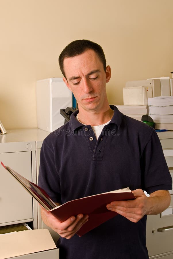 Caucasian Male in File Room Reading Papers Inside a Folder Stock Image ...