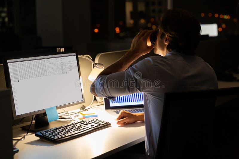 Caucasian Male Programmer Sitting at Desk, Drinking Coffee, Using Computer with Coding on Screen ...