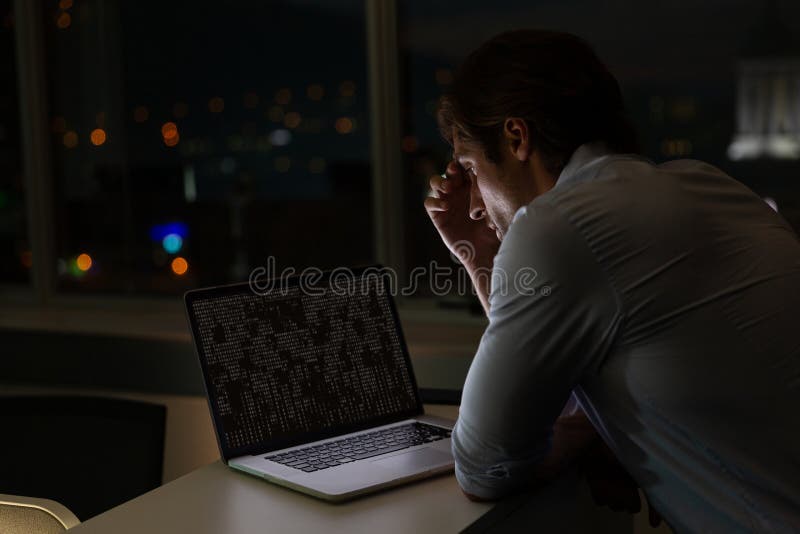 Caucasian Male Programmer Sitting At Desk Using Laptop With Coding On