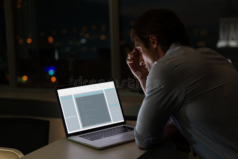Caucasian Male Programmer Sitting At Desk Using Laptop With Coding On