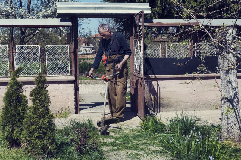 Caucasian Man Cutting Grass in His Front Yard. Village Place Stock ... Caucasian Man Cutting Grass in His Front Yard. Village Place Stock ...