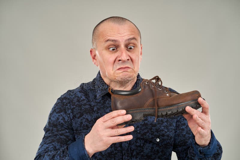 Man Holding a Stinking Shoe Stock Image - Image of shoe, face: 172076019
