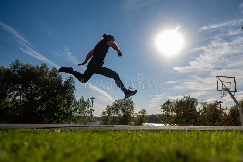 Caucasian Man Jumping with High Hip Raise Outdoors. Stock Image - Image ...