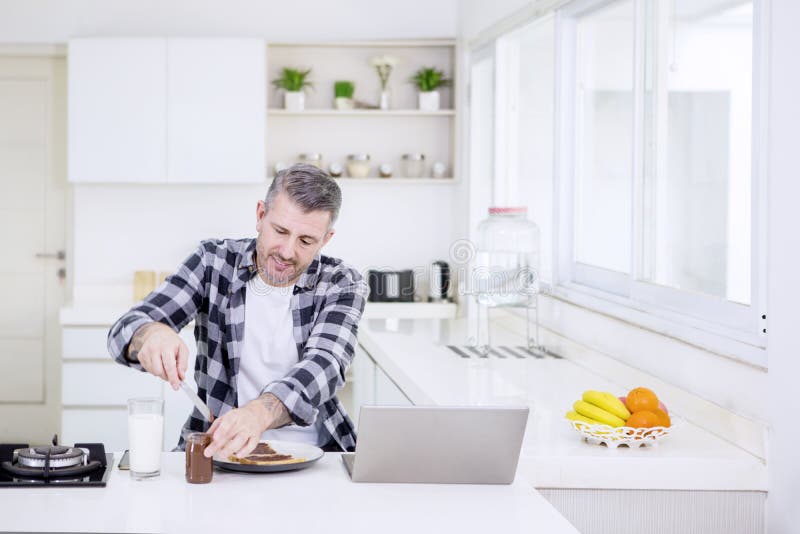 Mature Man Making Breakfast while Working Stock Image - Image of ...