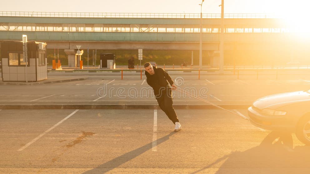 Caucasian Man Pulling a Car with a Rope. Stock Photo - Image of service ...