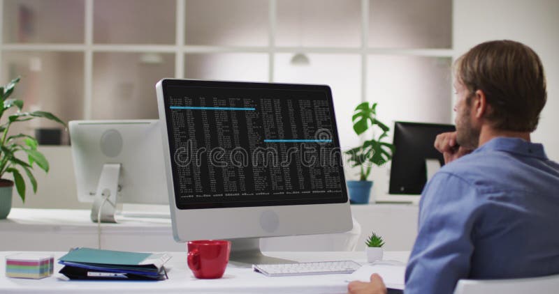 Caucasian Man Sitting at Desk Watching Coding Data Processing on ...