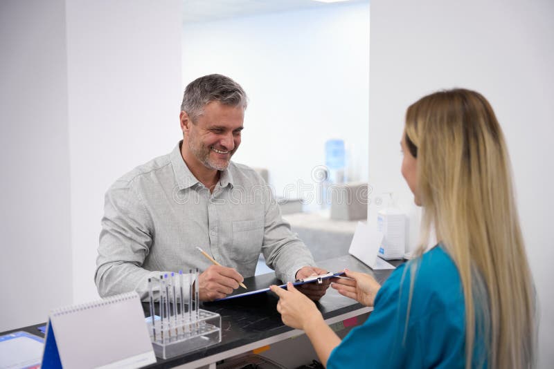 Caucasian Man Smiling Signing Documents in the Hospital Stock Photo ...