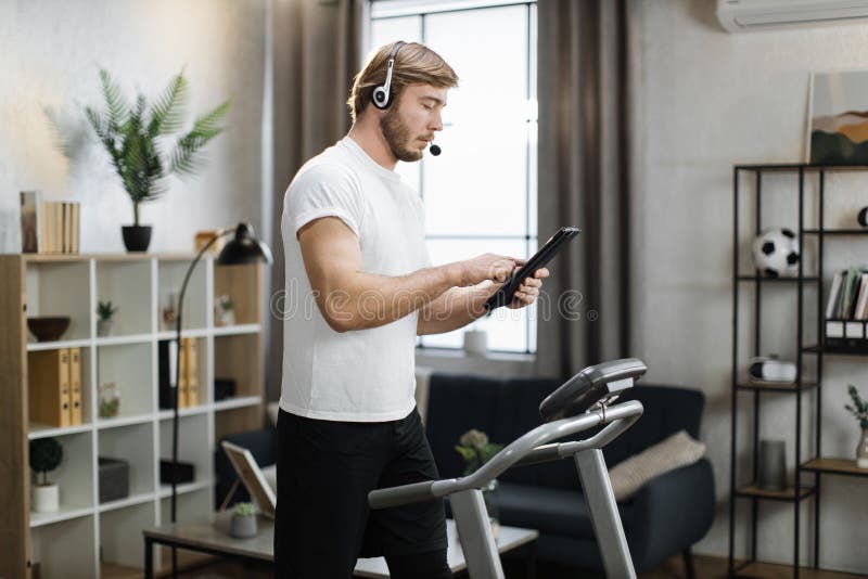 Caucasian Man in Sport Clothes Using Headset Working Tablet Computer ...