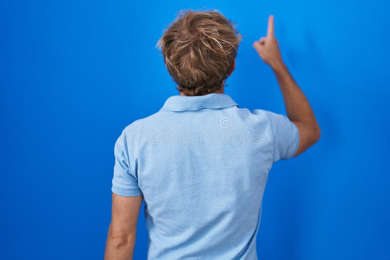 Caucasian Man Standing Over Blue Background Posing Backwards Pointing ...
