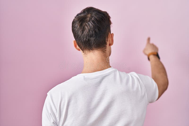 Caucasian Man Standing Over Pink Background Posing Backwards Pointing ...