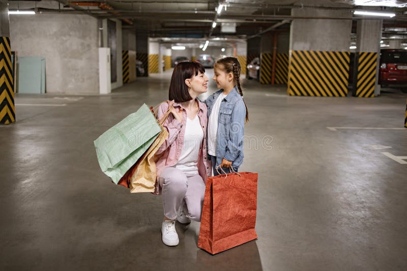 Caucasian Mother And Her Young Daughter In Underground Parking Lot