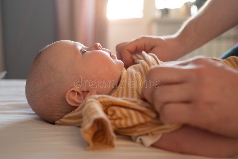 Caucasian Parent Changing and Dressing Up Baby. Stock Image - Image of ...