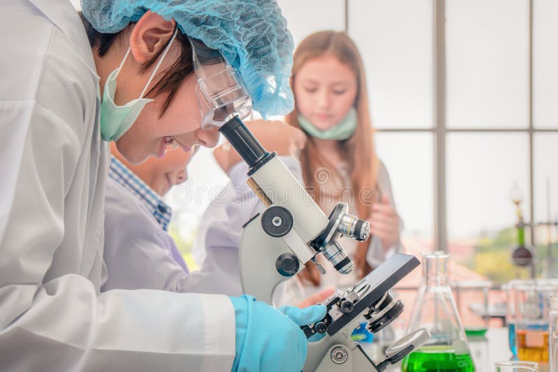 Elementary School Student Girl Uses a Microscope for Science Project in ...