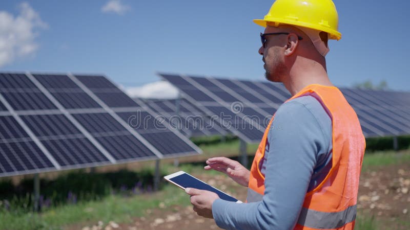 Caucasian Solar Engineer Using Tablet in Front of the Solar Power ...