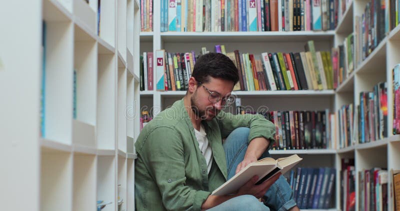 Caucasian Student Man Reading Book, Sitting among Stack of Books on ...