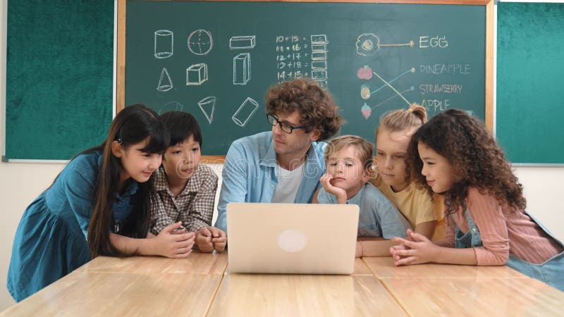 Caucasian Teacher and Diverse Student Looking at Laptop at Classroom ...