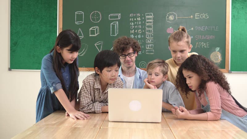 Caucasian Teacher and Diverse Student Looking at Laptop at Classroom ...