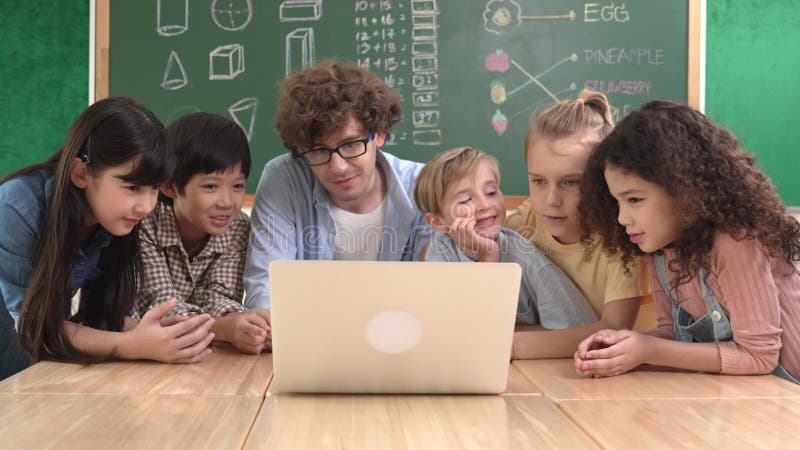Caucasian Teacher and Diverse Student Looking at Laptop at Classroom ...