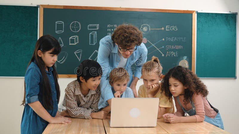 Caucasian Teacher and Diverse Student Looking at Laptop at Classroom ...