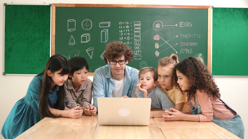 Caucasian Teacher and Diverse Student Looking at Laptop at Classroom ...