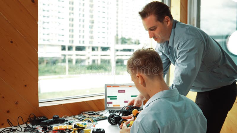 Teacher Help Student Fixing Car Model and Giving Advise at Class ...