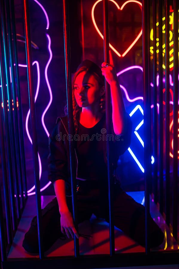 Caucasian Woman in a Cage in a Neon Studio. Stock Image - Image of ...