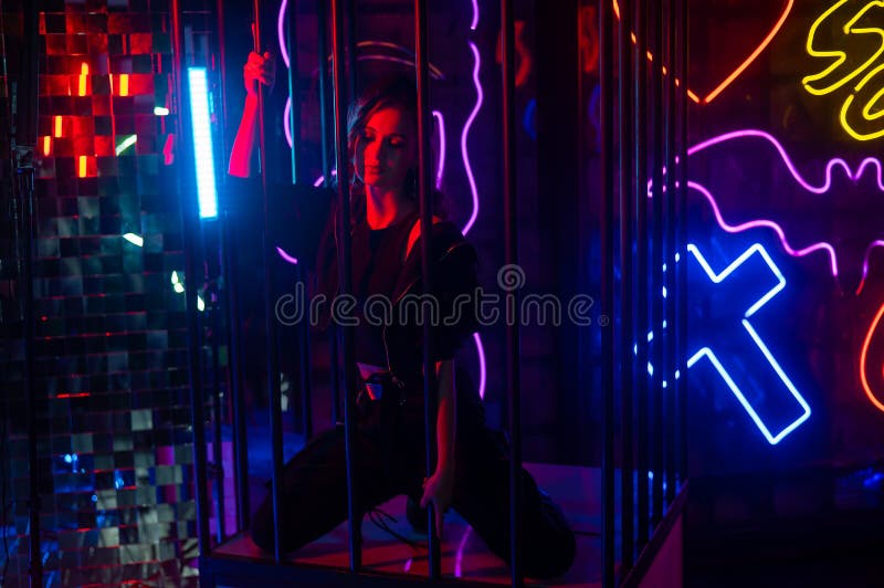 Caucasian Woman in a Cage in a Neon Studio. Stock Image - Image of ...