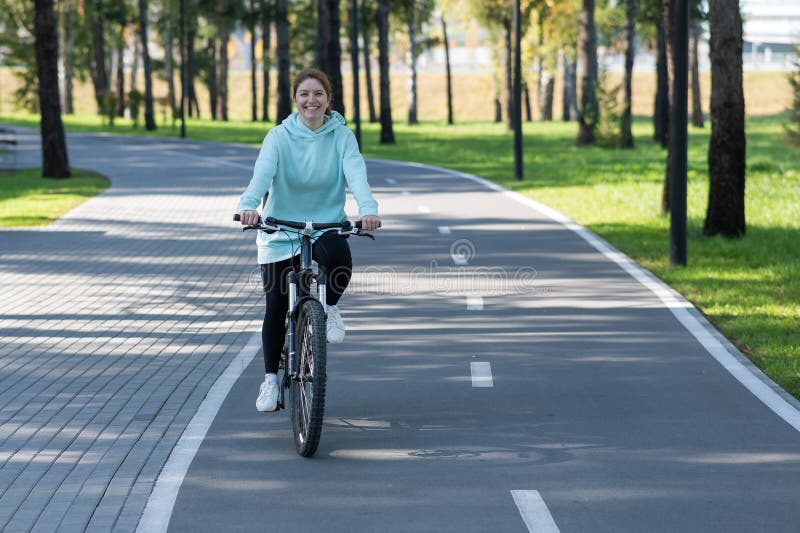 Caucasian Woman Riding a Bicycle in the Park. Stock Image - Image of ...