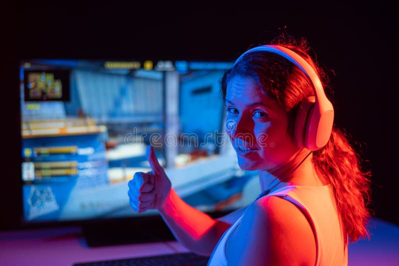 Caucasian Woman Showing Thumb Up while Playing Computer in Neon Light ...