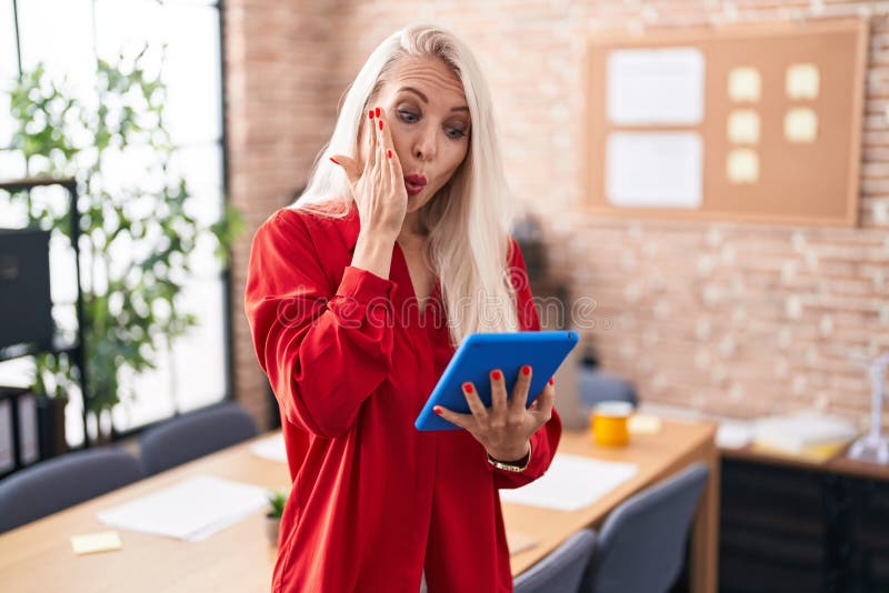 Caucasian Woman Working at the Office with Tablet Afraid and Shocked ...