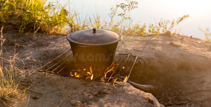 Cauldron on fire at sunset stock image. Image of firewood - 111117255