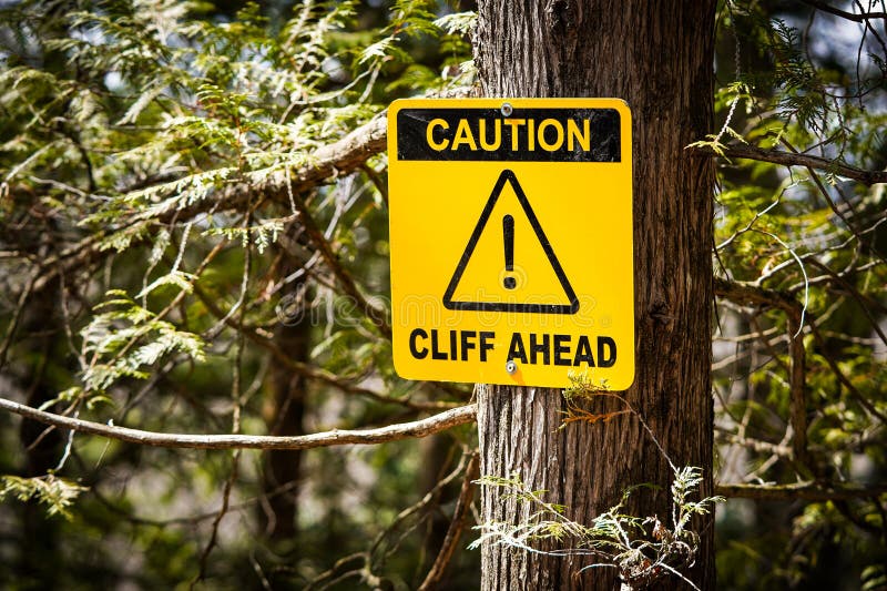 Caution Cliff Ahead Sign on Cedar Tree on a Forest Trail Stock Photo ...