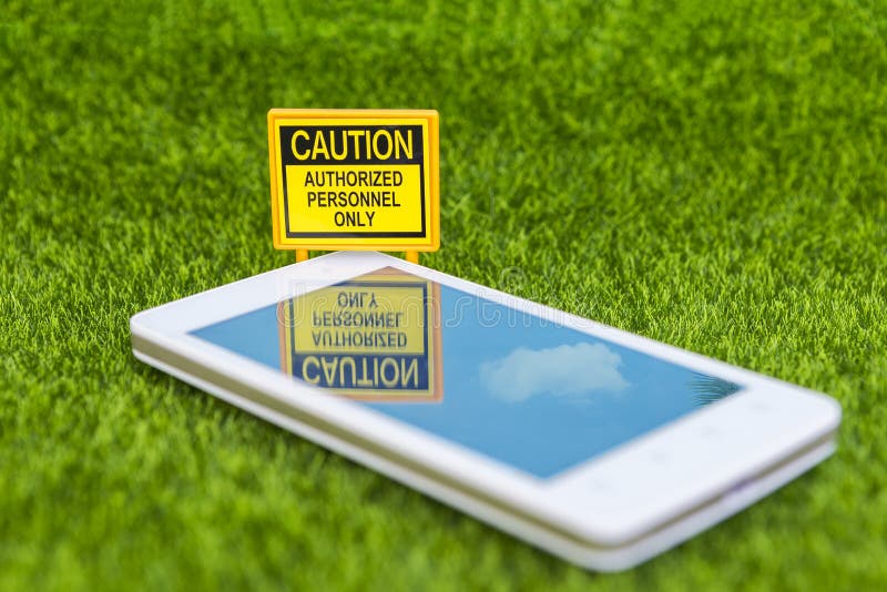 Caution Sign with Smartphone on Green Grass Background Stock Photo ...
