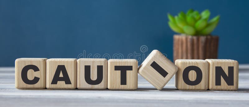 CAUTION - Word on Wooden Cubes on the Background of a Cactus Stock ...