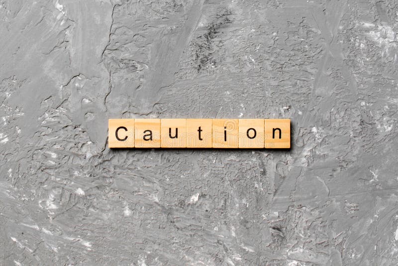 CAUTION Word Written on Wood Block. CAUTION Text on Cement Table for ...