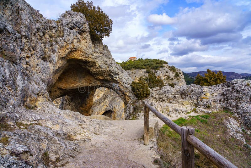 Cave Carved into the Rock with Cliff Views of the Nearby High Mountains ...