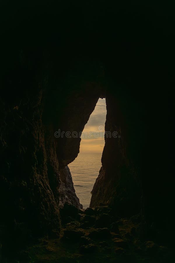 A Cave with a Small Opening in the Wall. the Cave is Dark and the Sky ...