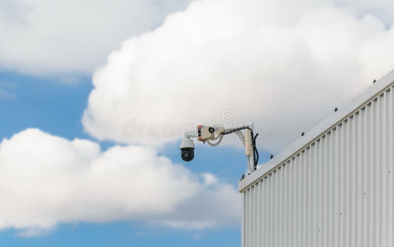 CCD Surveillance Camera Mounted on a Hangar in Front of a Cloudy Blue ...